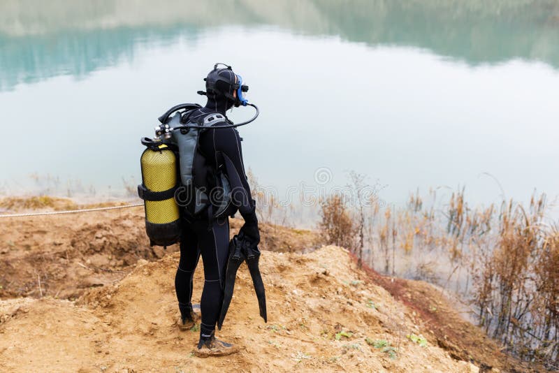 A Lifeguard in a Wetsuit is Preparing To Dive into the Pond. Search at ...