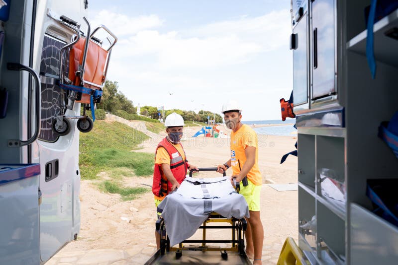 Lifeguard Working on the Beach Using a Stretcher from Ambulance Stock ...