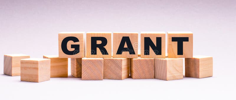 The Word Grant On Wooden Cubes With Stacked Books Background. Education ...