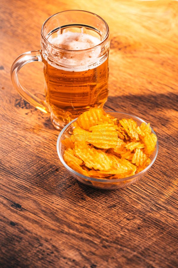 Light Beer Mug with a Bowl of Potato Chips on a Wooden Table Stock ...