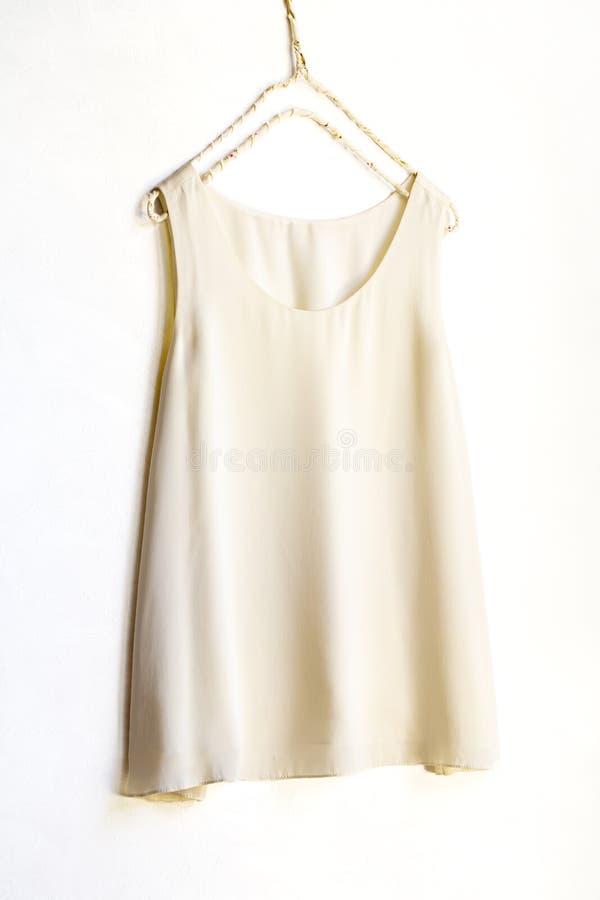 Light Beige or White Tank Top Hanging on a Hanger in a White Wall Stock ...