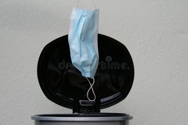 Light Blue Disposable Face Mask Hanging Above Bin before Being Thrown ...