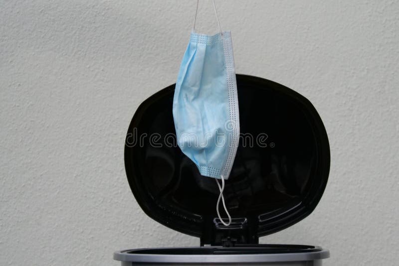 Light Blue Disposable Face Mask Hanging Above Bin before Being Thrown ...