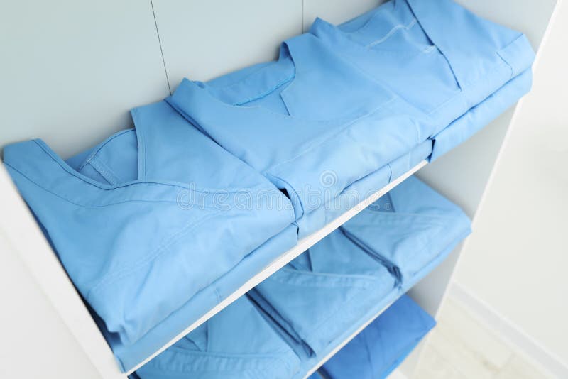Light Blue Medical Uniforms on White Rack, Above View Stock Photo ...