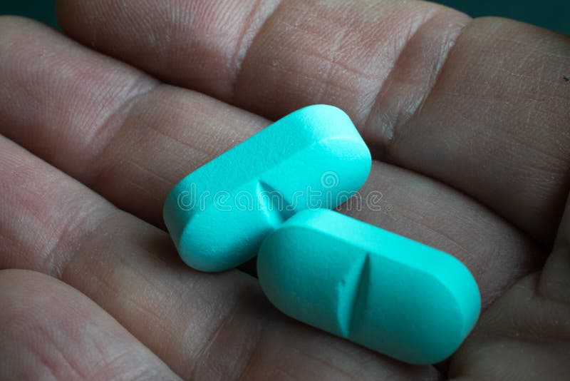Light blue pill on hand stock image. Image of medicine - 217046027