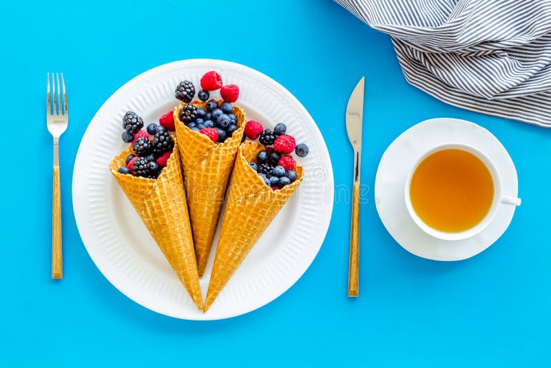 Light Breakfast with Fresh Berries in Waffle Cones and Cup of Tea on ...