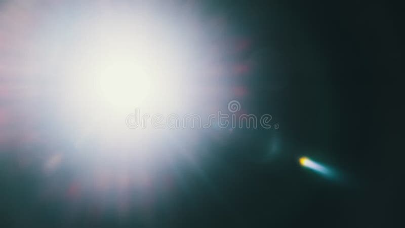 The Light of a Bright Flashlight Directed at the Camera Moves from Side ...