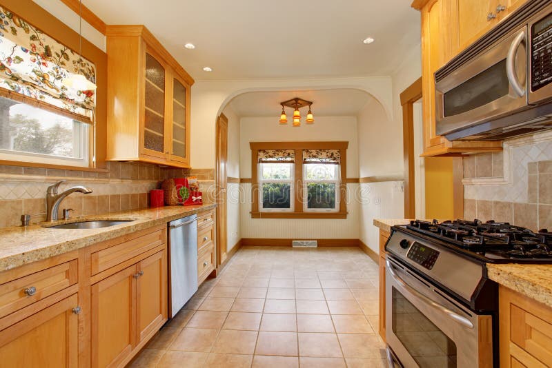 Light Brown Tones Kitchen Interior with Tile Floor and Steel Appliances ...
