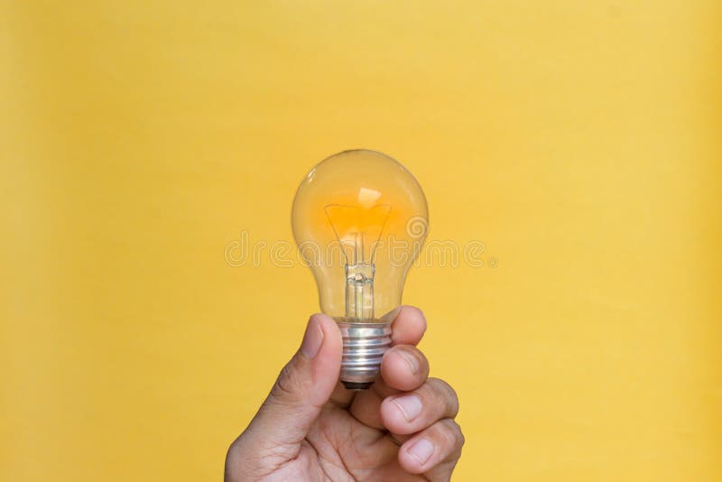 The Light Bulb in the Hand of a Man with a Yellow Background Stock ...