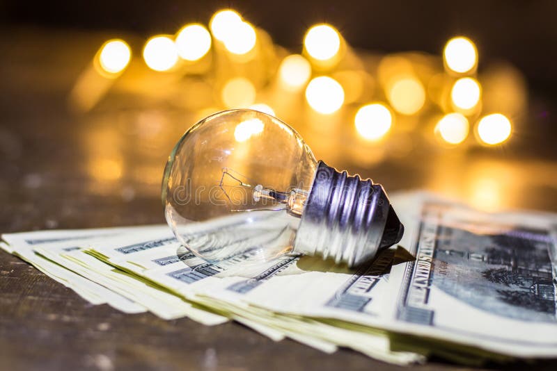 Light bulb on banknotes stock image. Image of increasing - 259637099