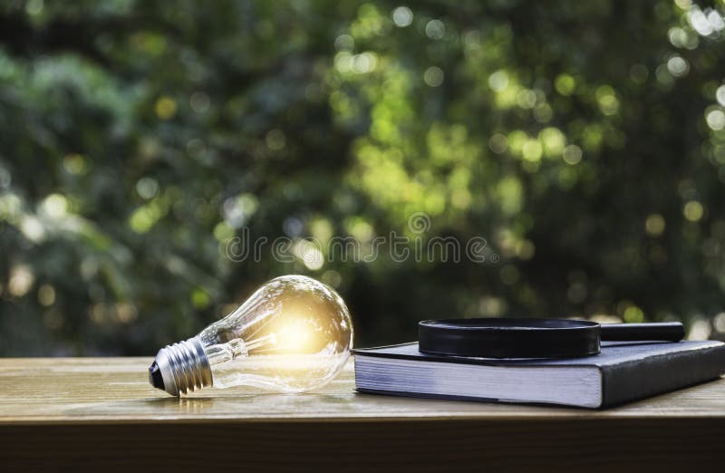 Light Bulb and a Book on Table and Copy Space for Insert Text Stock ...