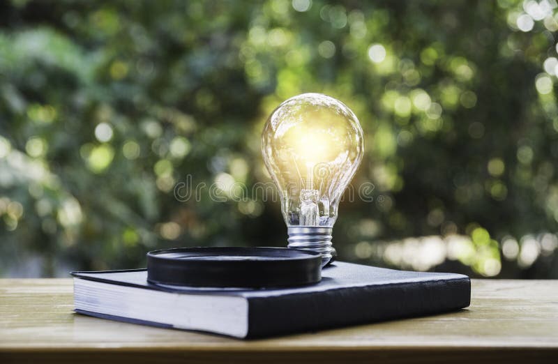 Light Bulb and a Book on Table and Copy Space for Insert Text Stock ...