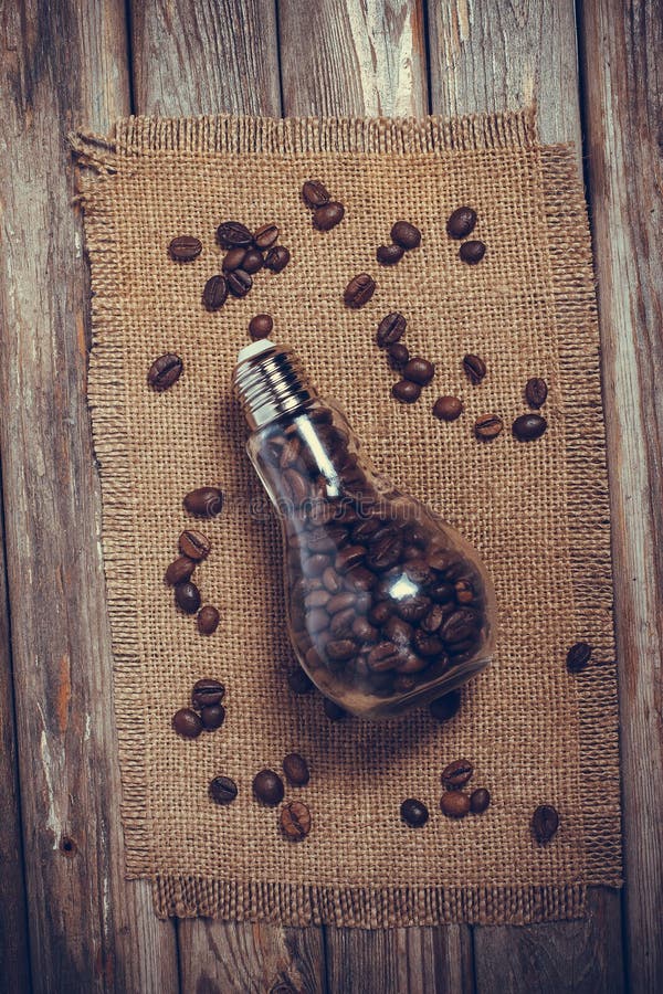 Light Bulb Bottle with Coffee Grains on Vintage Surface Stock Photo ...