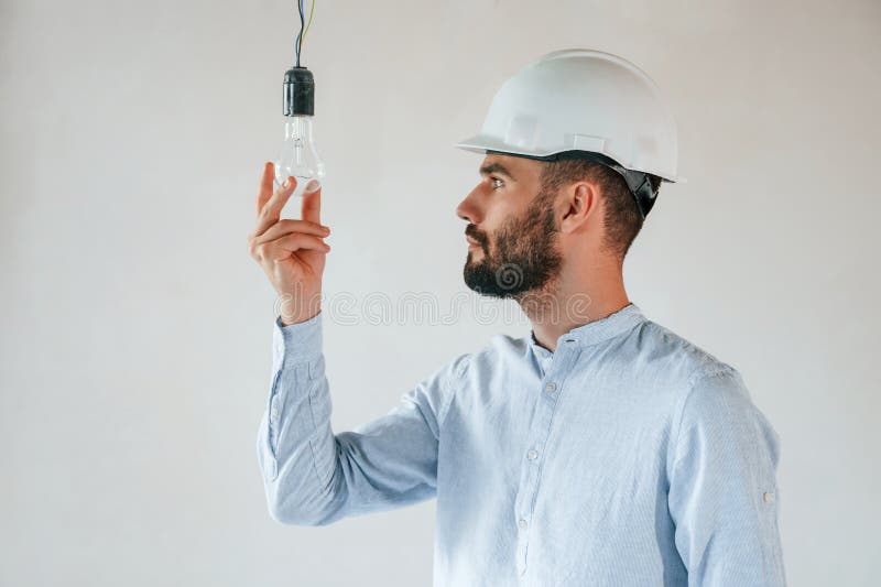 With Light Bulb in Bright Room. the Man is Making Repairs in the ...