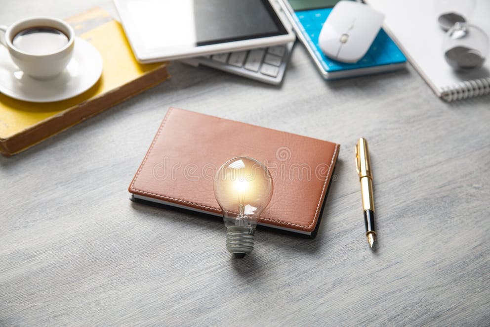 Light Bulb with a Business Objects on the Table Stock Photo - Image of ...