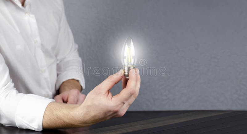 Light Bulb in Hand. a Man Holds a Light Bulb in His Hand. Idea. a ...