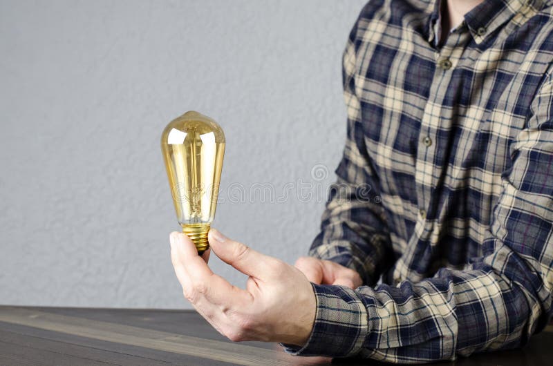 Light Bulb in Hand. a Man Holds a Light Bulb in His Hand. Idea. a ...
