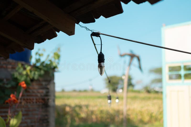 A Light Bulb Hanging from a Wire Stock Photo - Image of illuminated ...
