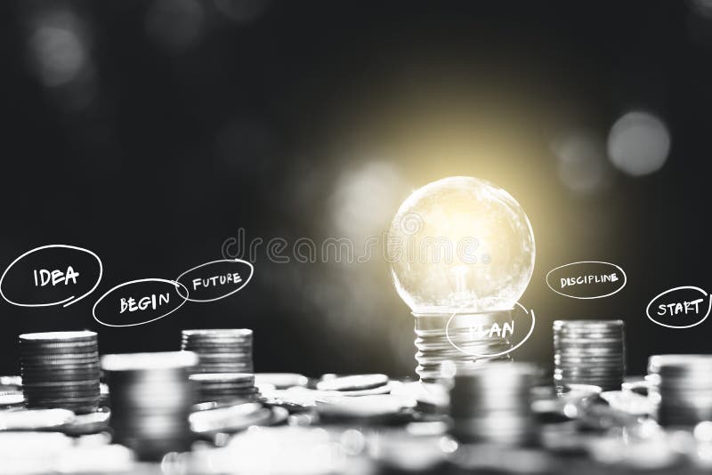 The Light Bulb is Illuminating while the Coins are Stacked Around Stock ...
