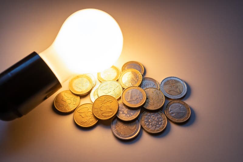 Light Bulb Lit Illuminating Coins for the High Cost of Electricity and ...