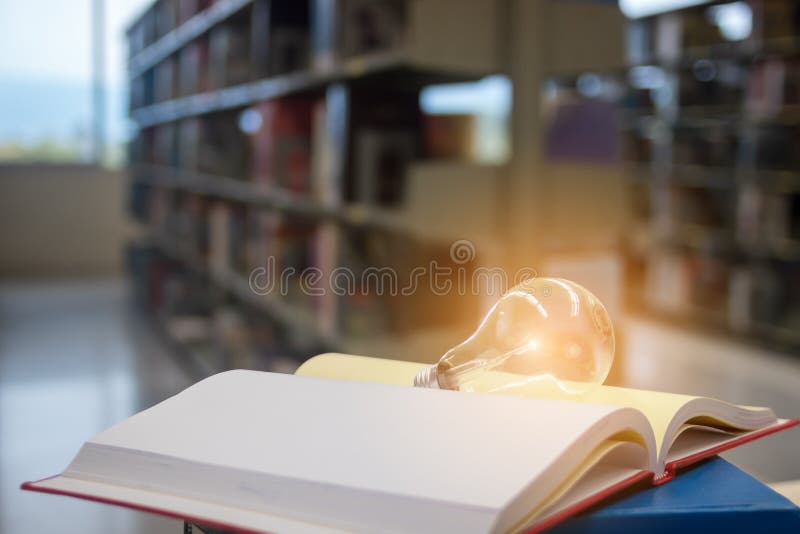 Light Bulb on Open Book in Library. Success Concept Stock Photo - Image ...