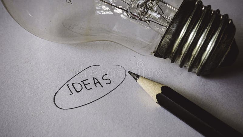 Light Bulb and Pencil with the Word "IDEAS" Written on Paper Stock ...