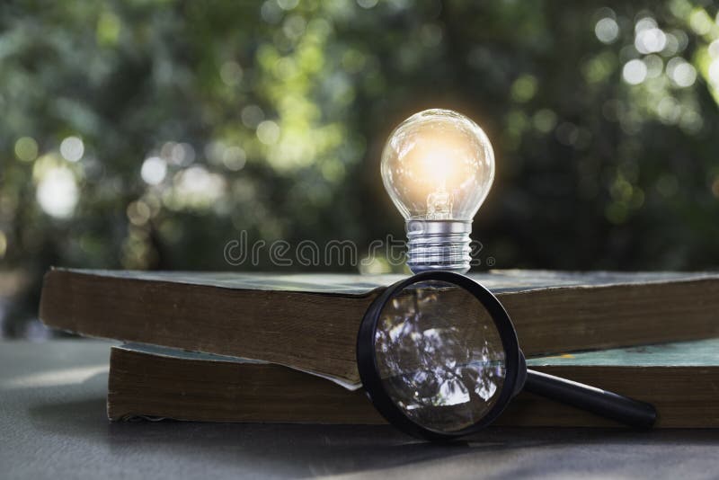 Light Bulb and Pile of Book on Table and Copy Space for Insert Text ...