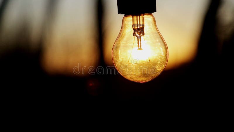 The Setting Sun Shines through a Light Bulb. Stock Footage - Video of ...
