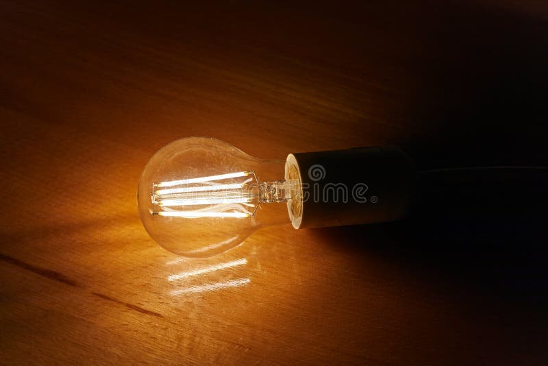 Light bulb on a table stock photo. Image of conventional - 142332900