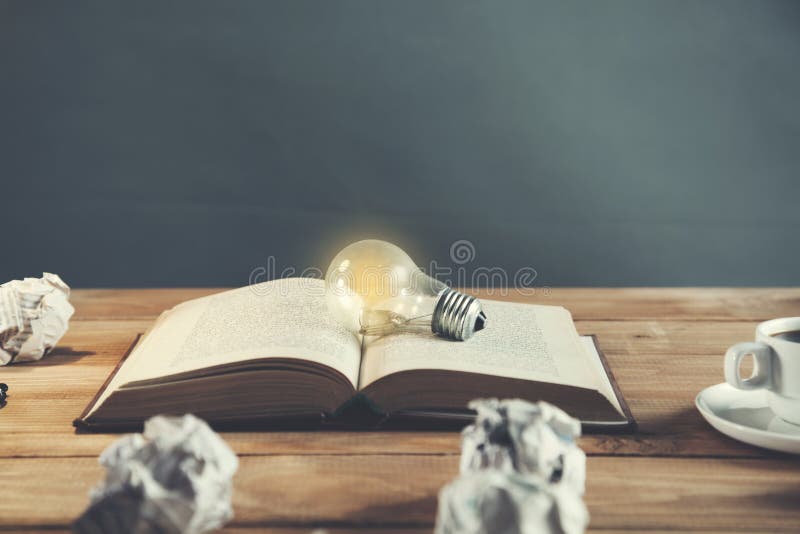 Light Bulb on Vintage Book with Crumpled Papers Stock Image - Image of ...