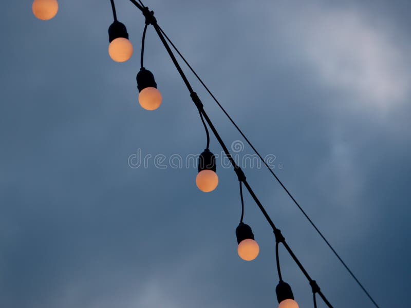 Light Bulbs Hanging on a Electricity Wire in Cloudy Sky Background ...