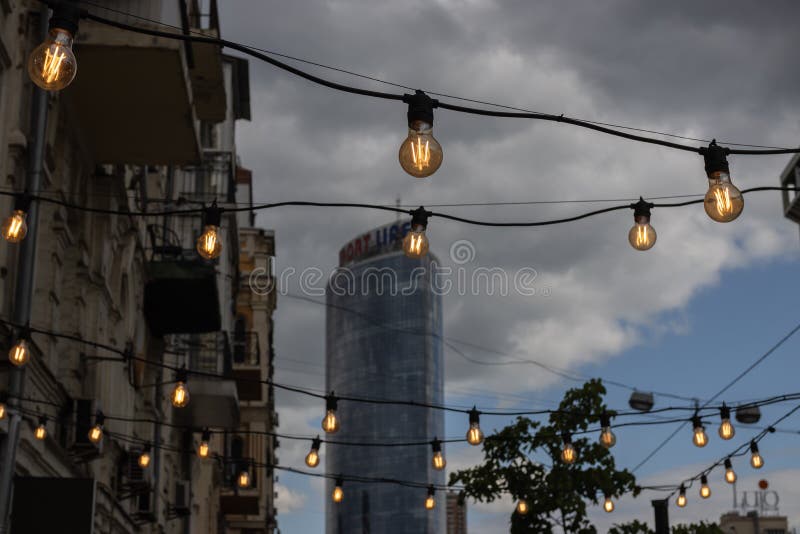 Light Bulbs on String Wire Hanging on Poles Against Sunset Sky ...