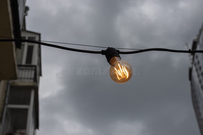 Light Bulbs on String Wire Hanging on Poles Against Sunset Sky Stock ...