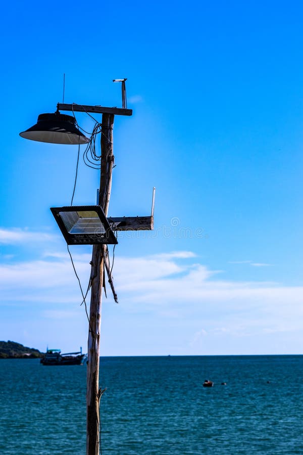 A Light Fixture is on a Pole by the Ocean Stock Image - Image of ...