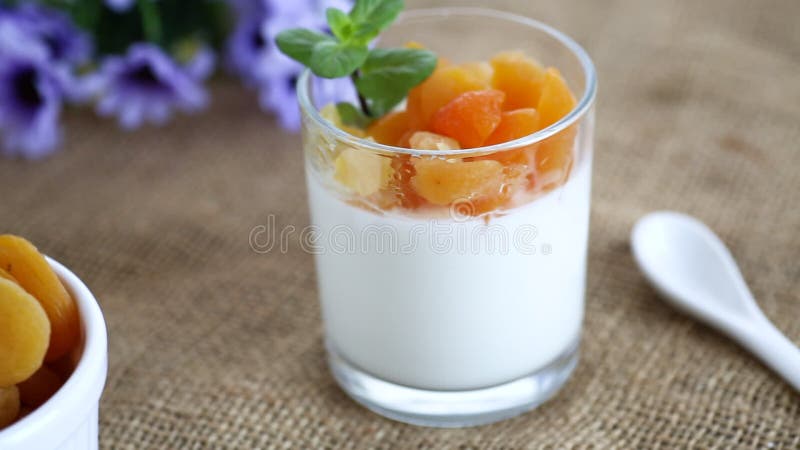 Light Fruit Yogurt with Dried Apricots on Dark Wooden Table Stock Video ...