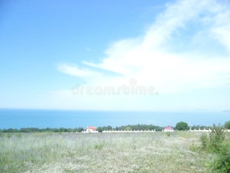 Light Green Field with the Sea. Stock Image - Image of green, blue ...