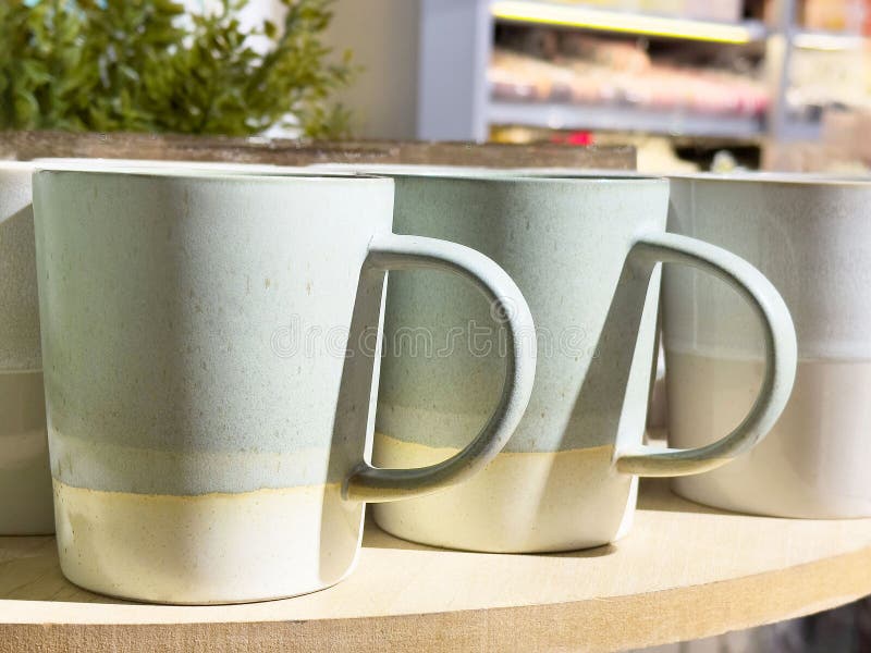 Light Green and White Ceramic Mugs on Wooden Shelf in Store Display ...