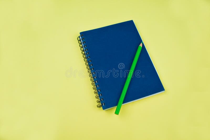 Light Green Writing Pencil Crayon on Top of a Blue Note Book Ready To ...