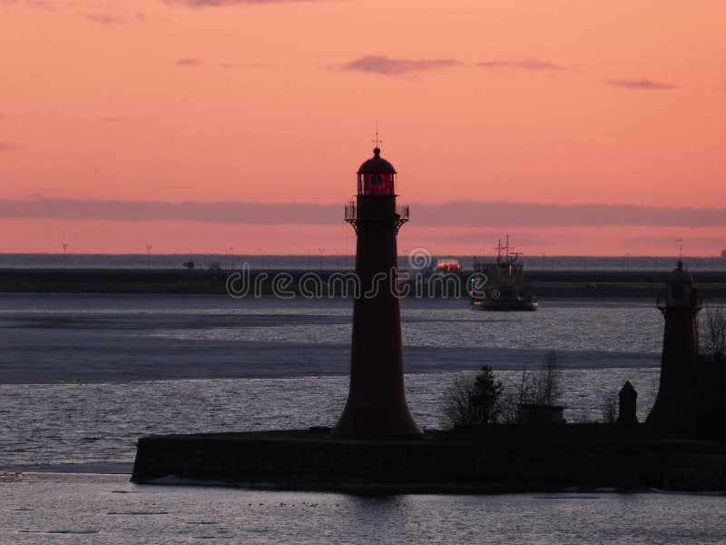 Light House in Harbor with Ship in Background and an Amazing Sunset ...