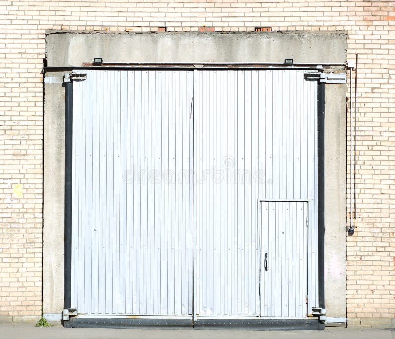 Light Metal Gate with a Door in a White Brick Wall Stock Image - Image ...