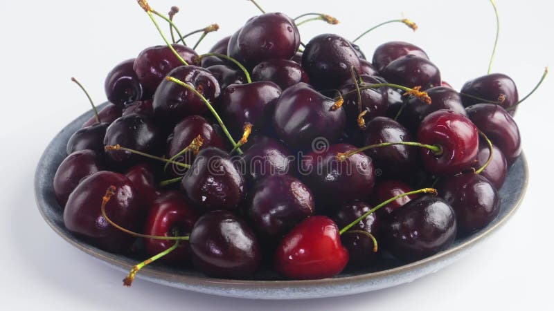 On a Light Plate of Ripe Dark Red Cherries Rotating in a Circle on a ...