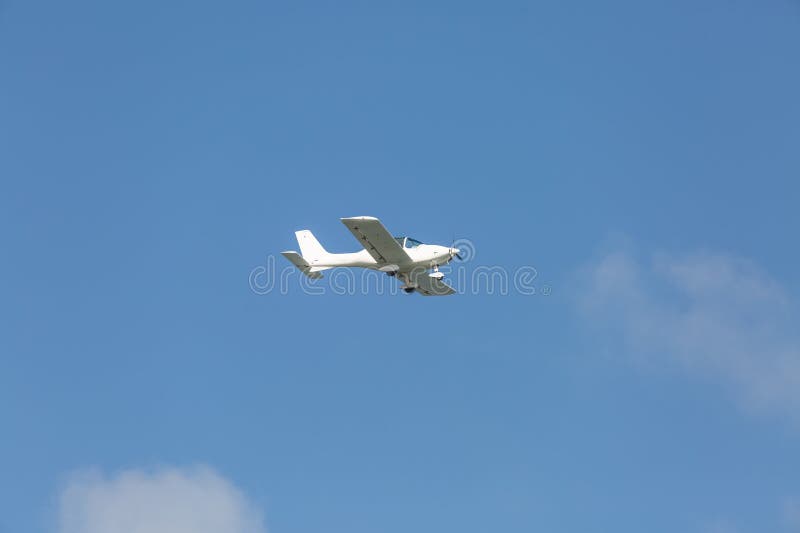 A Light White Plane Flies Across the Blue Sk Stock Image - Image of ...