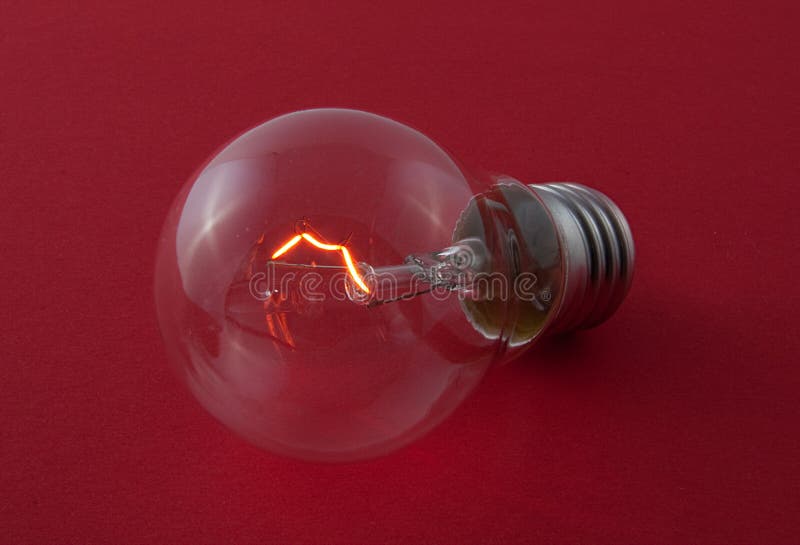 Lightbulb on a red surface stock photo. Image of watt - 13207152