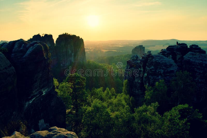 Lighted Rocks and Hills Bellow Sunset Sun on Horizon. Dark Silhouettes ...