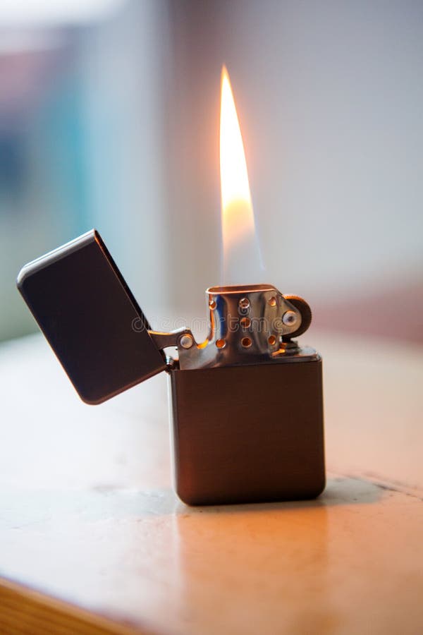 Lighter with Flame on Wooden Table Stock Image - Image of silver ...