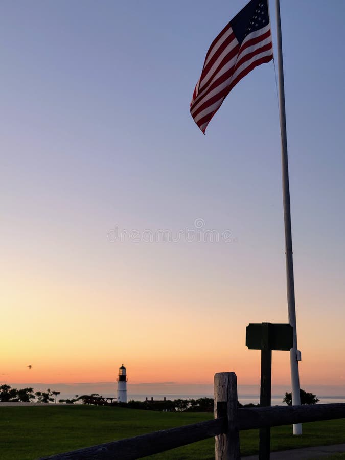 Lighthouse, American flag stock photo. Image of sunset - 228236832