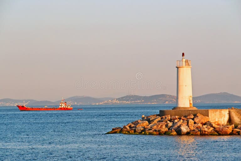 Lighthouse & Cargo Ship Stock Photo - Image of horizon, direction: 3751124