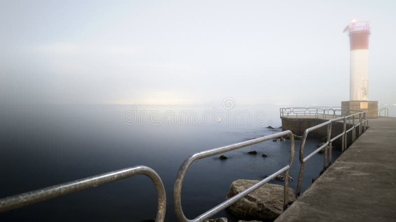 Lighthouse in fog stock photo. Image of ocean, beach - 219584412
