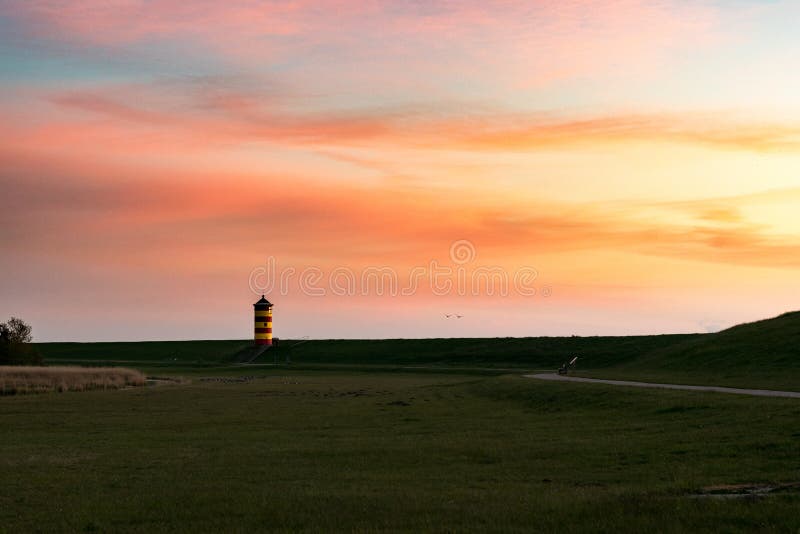 Lighthouse in a Green Field by the Sea during Sunset Stock Photo ...