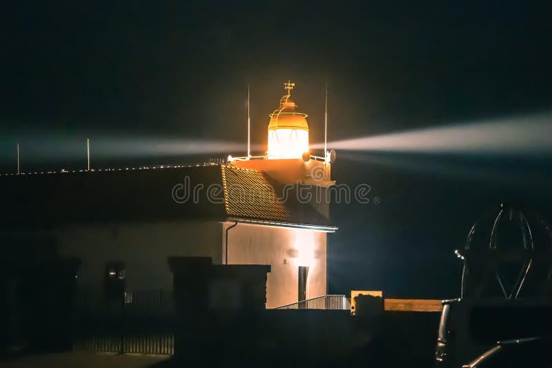 Lighthouse at Night with Bright Beam of Light Cutting through the ...
